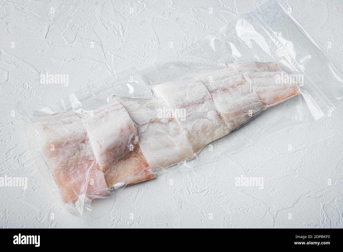 Raw haddock fish skinless plastic vacuum packaged, on white background ...