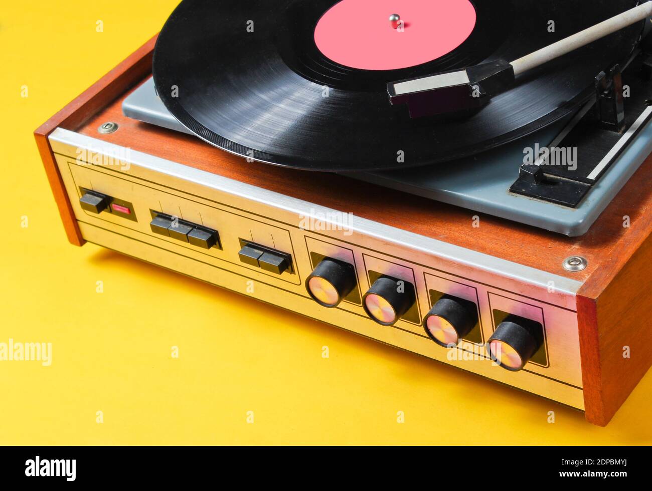 Fragment of a vinyl record player with a plate on a yellow background ...