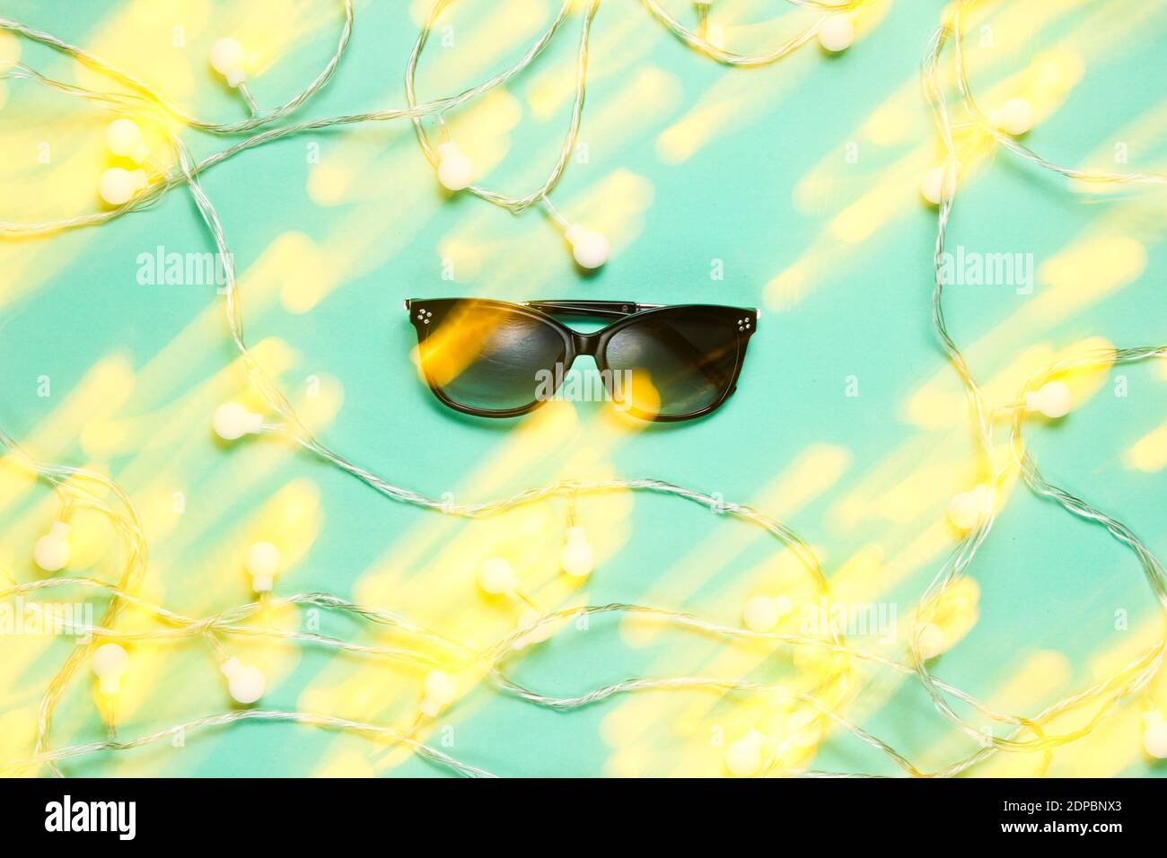 Stylish sunglasses with a light effect offset from the garlands on a ...