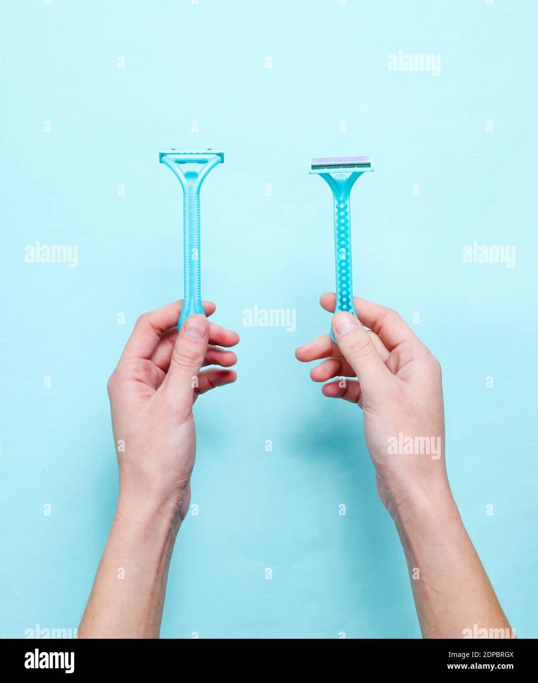 Women's hands hold two shaving razor for epilation on a blue background ...