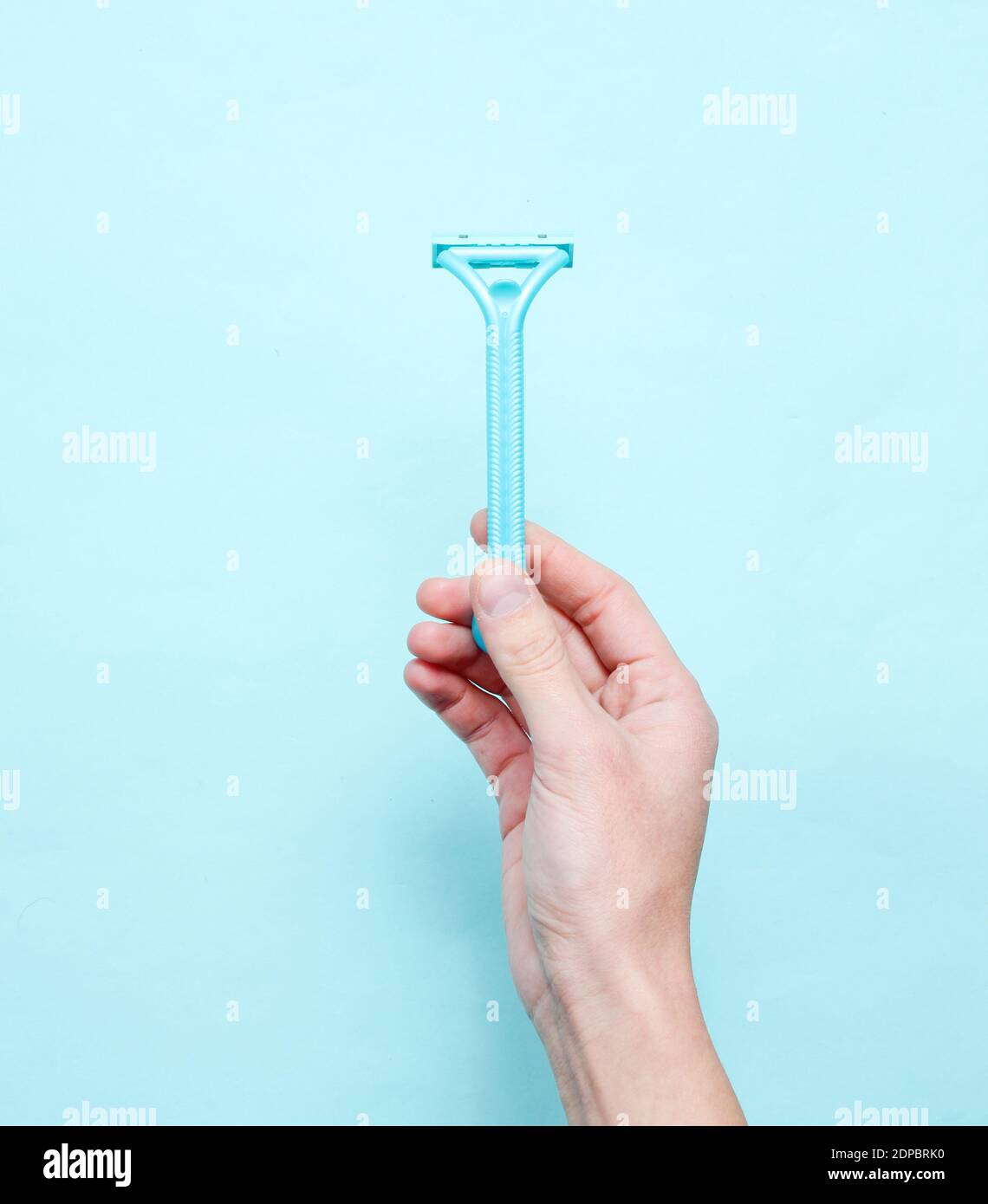 Female hand holding razors for epilation on a blue background. Top view ...