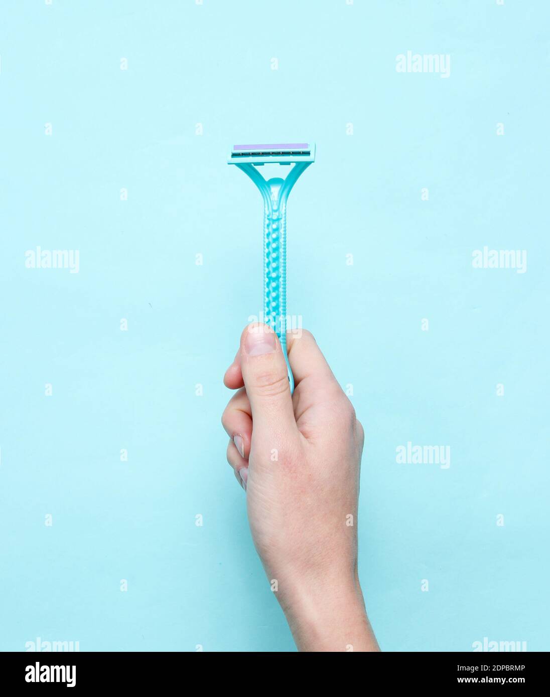 Female hand holding razors for epilation on a blue background. Top view ...