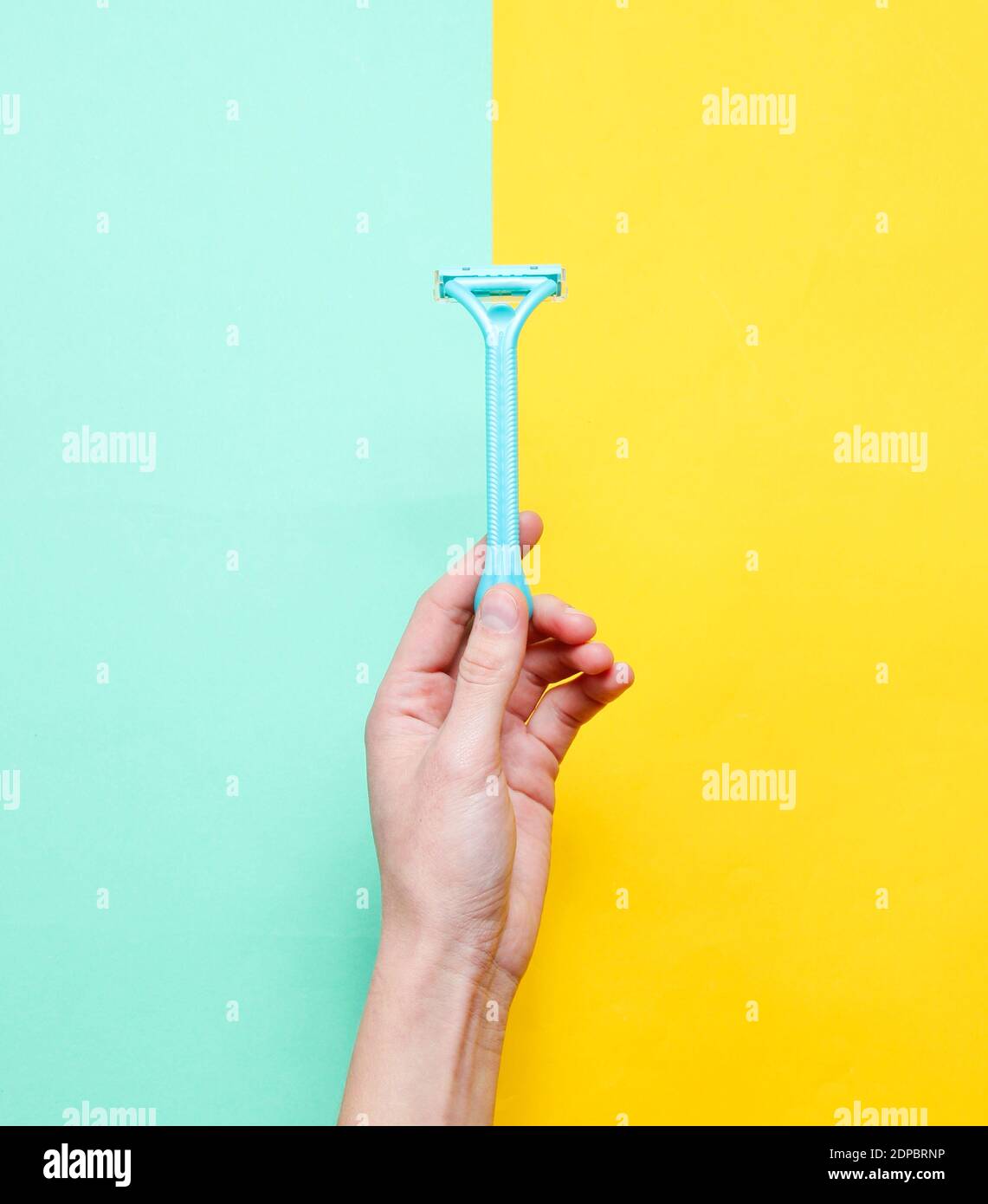Female hand holding razors for epilation on a blue yellow background ...
