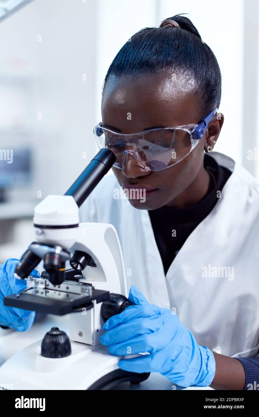 Black man looking through microscope hi-res stock photography and ...