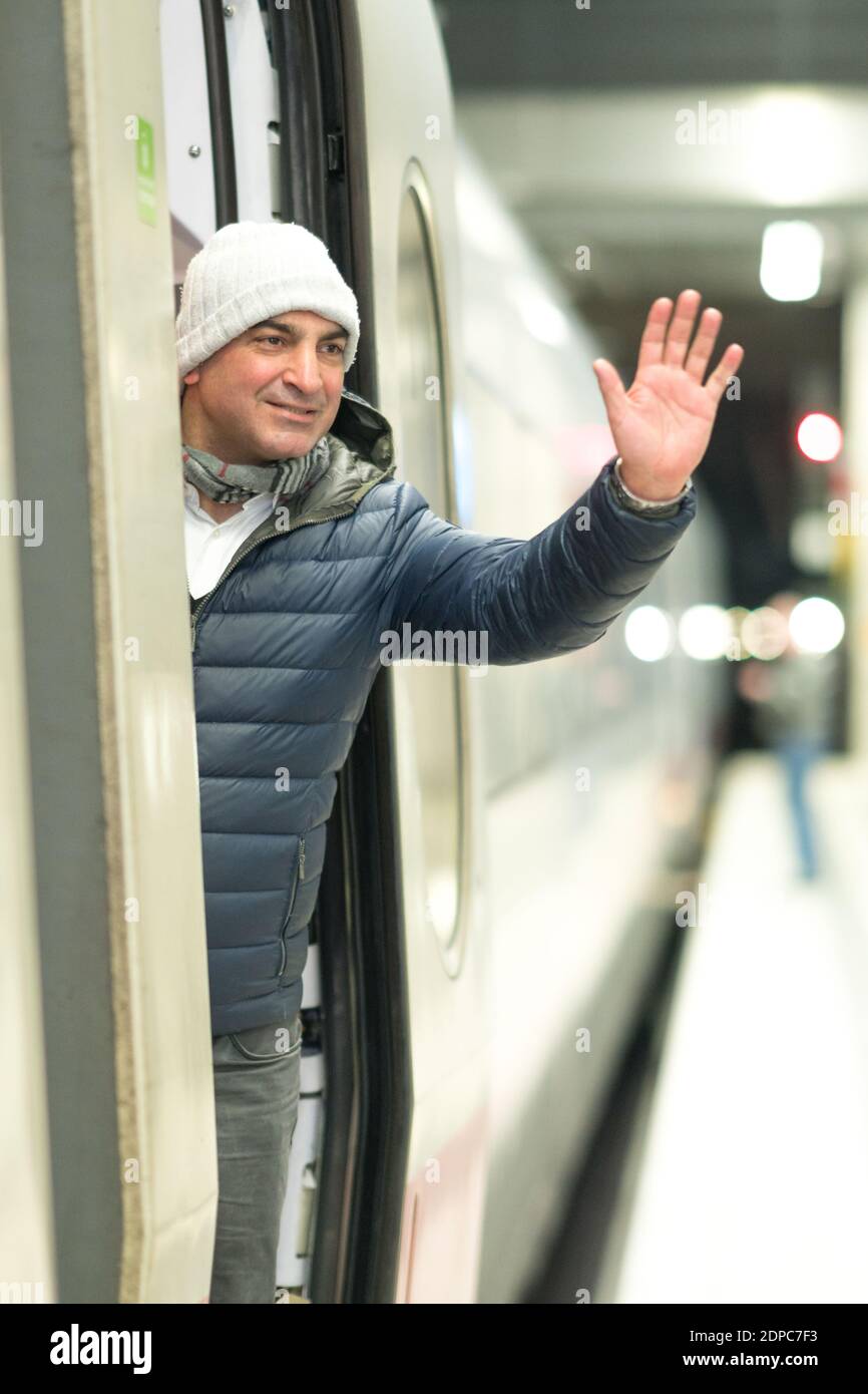 Man Waving Hand While Standing In Train Stock Photo - Alamy