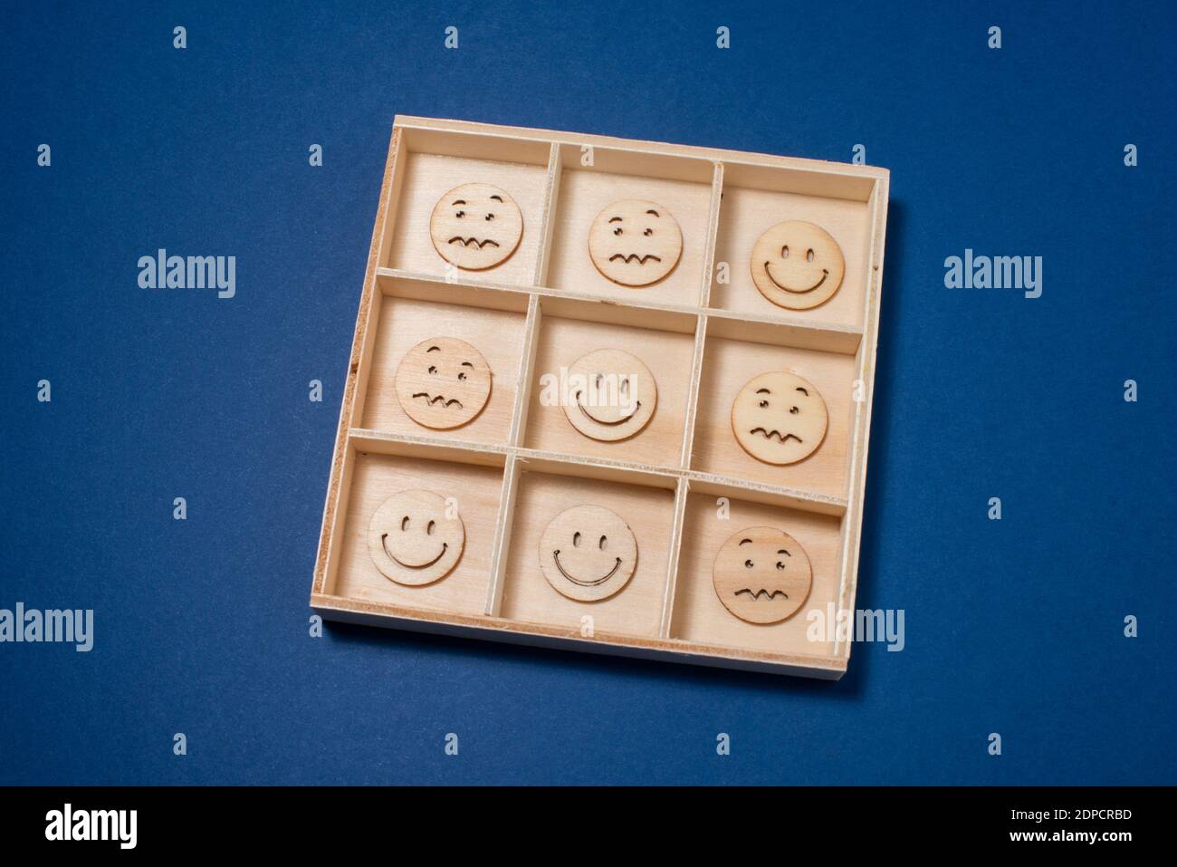 Tick Tack Toe with emoticons made of wooden circles. Positivity always ...