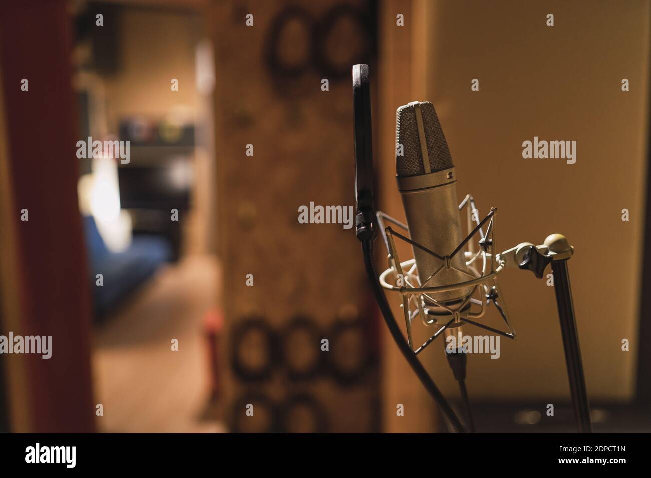 A horizontal side shot of a professional studio microphone with a pop ...