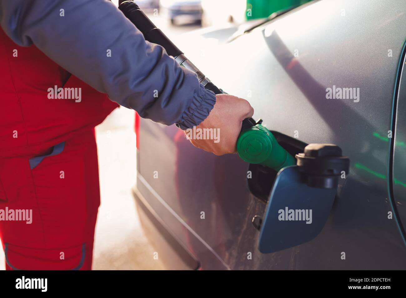 A shot of a person filling up their car with petrol at the gas station ...