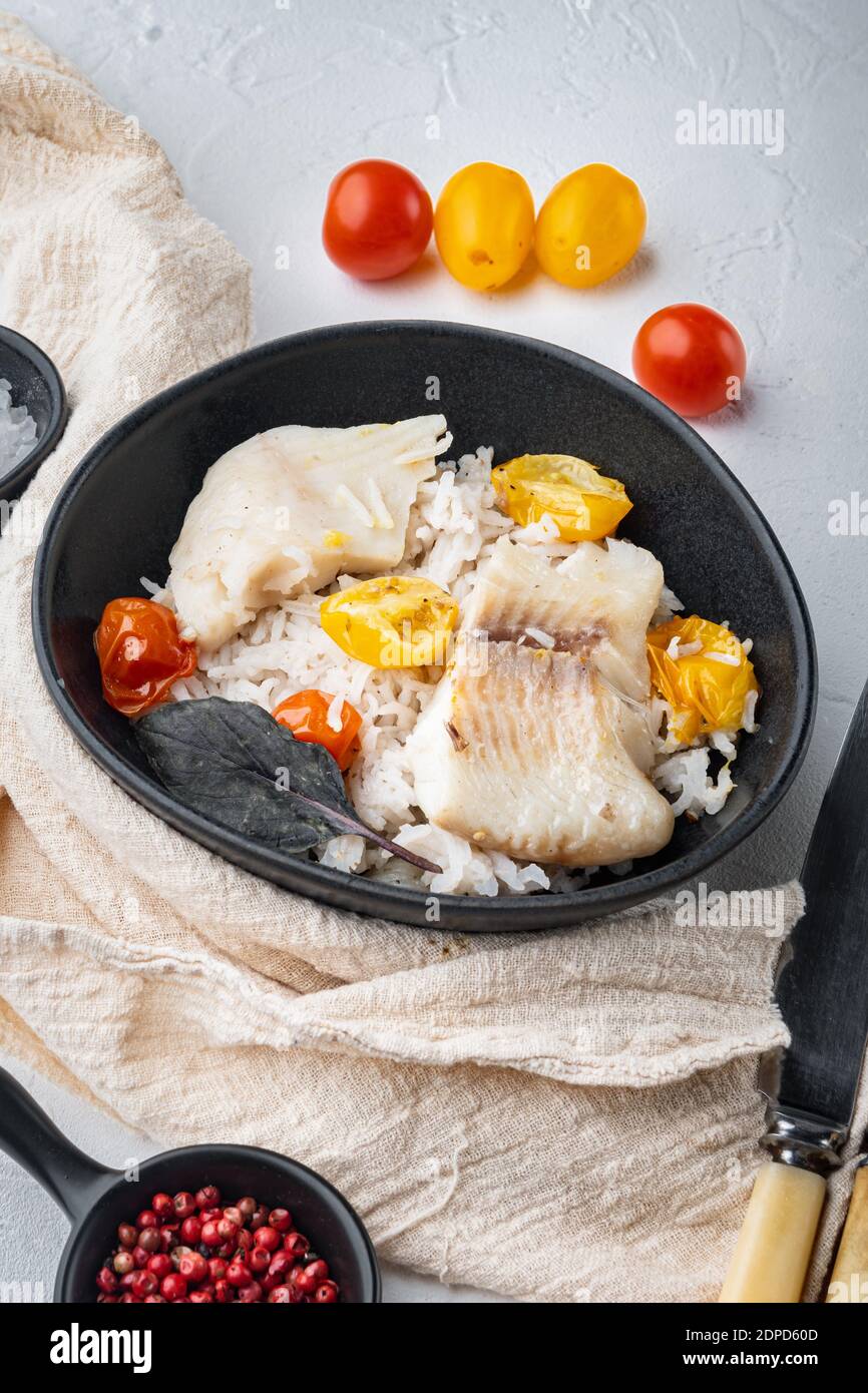 Tilapia fish with basmati rice and cherry tomatoes, in bowl, on white ...