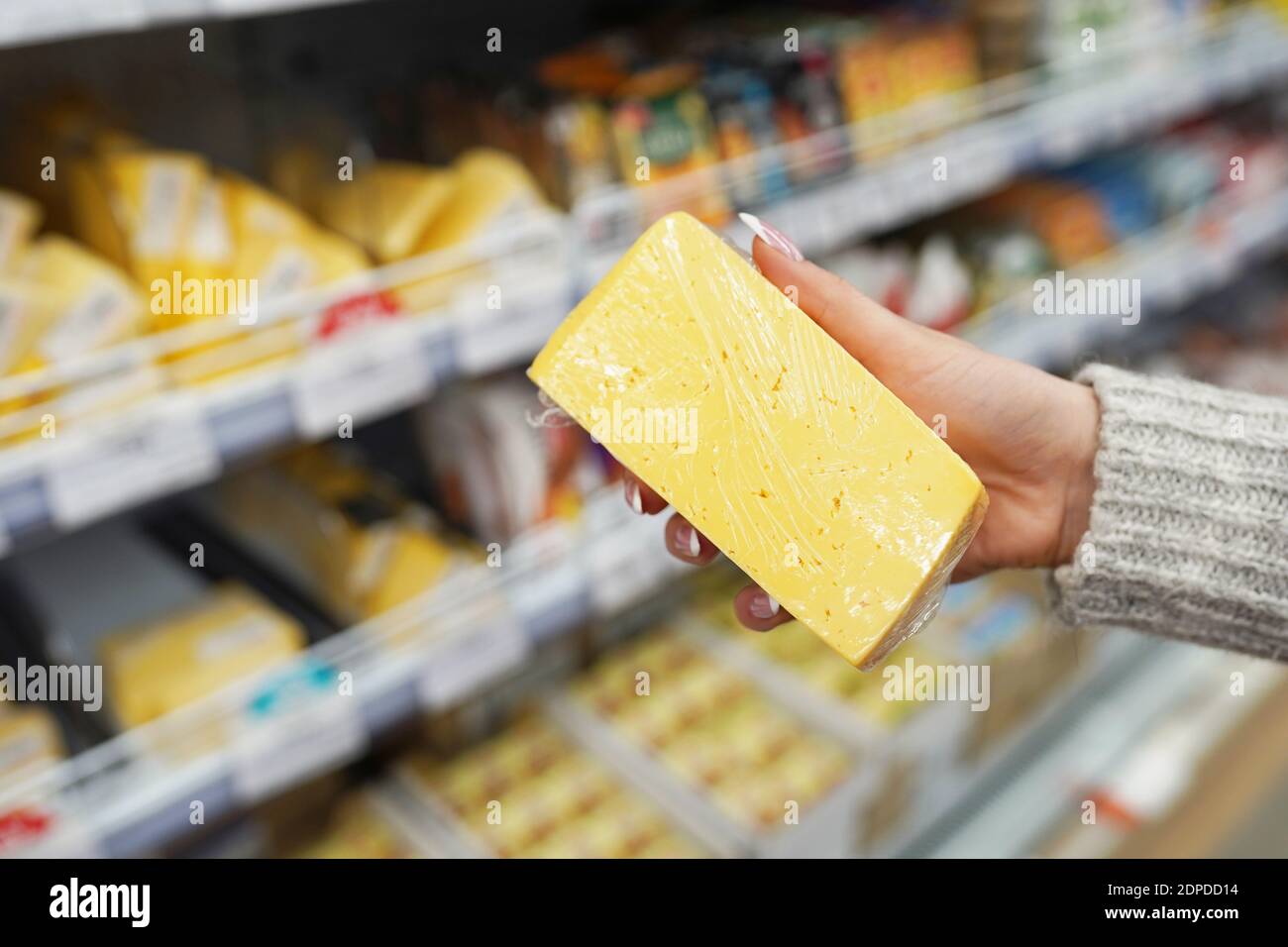 Female hand is holding cheese in the supermarket Stock Photo - Alamy
