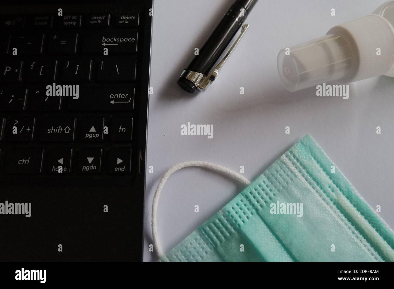 A high angle shot of a black laptop keyboard with a mask - pandemic ...