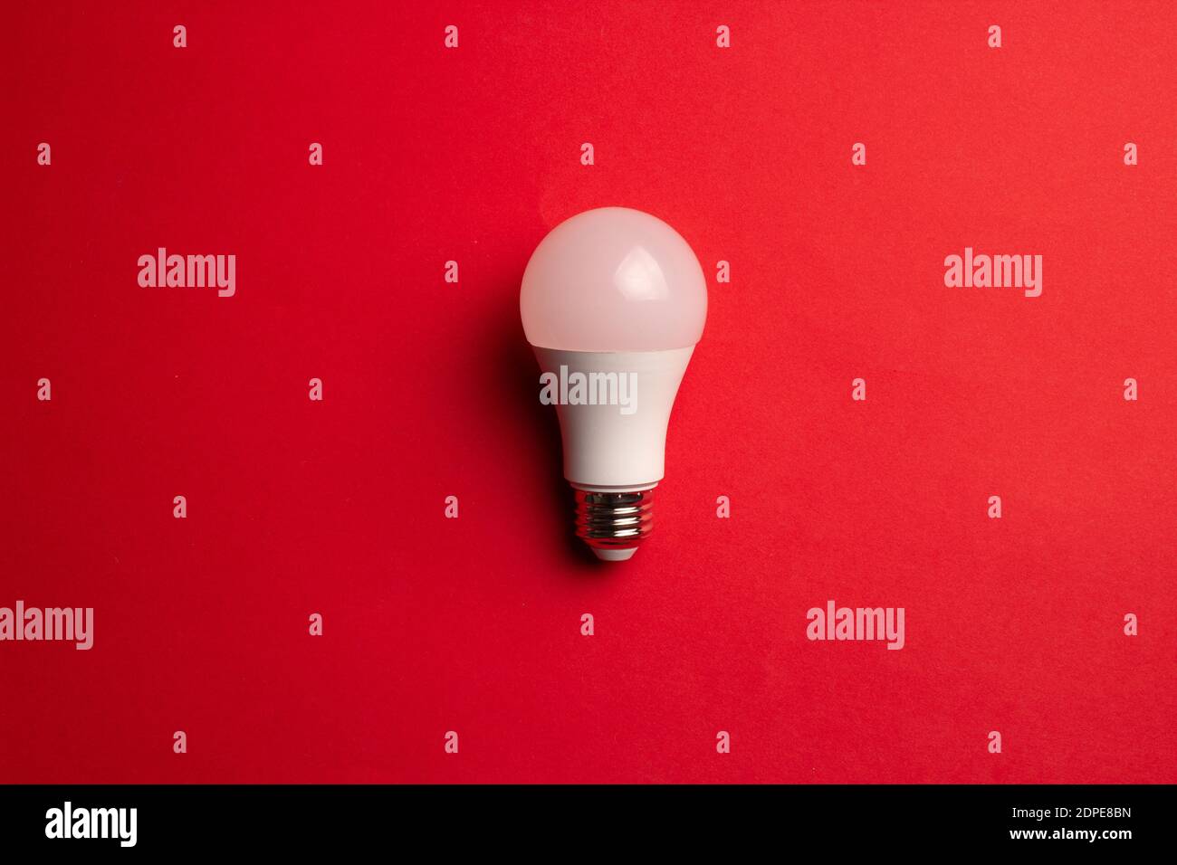 A top view of an electric light bulb on a red background Stock Photo ...