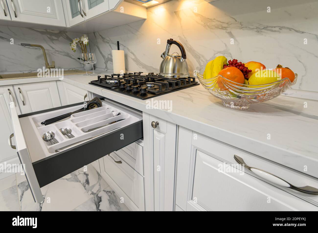 Open drawers with kitchenware at modern white kitchen Stock Photo - Alamy