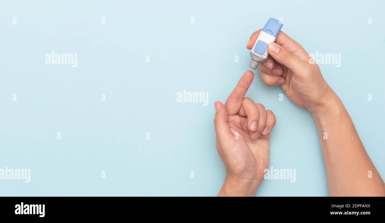 Man using lancet for diabetes, checking blood sugar level. Wide image ...