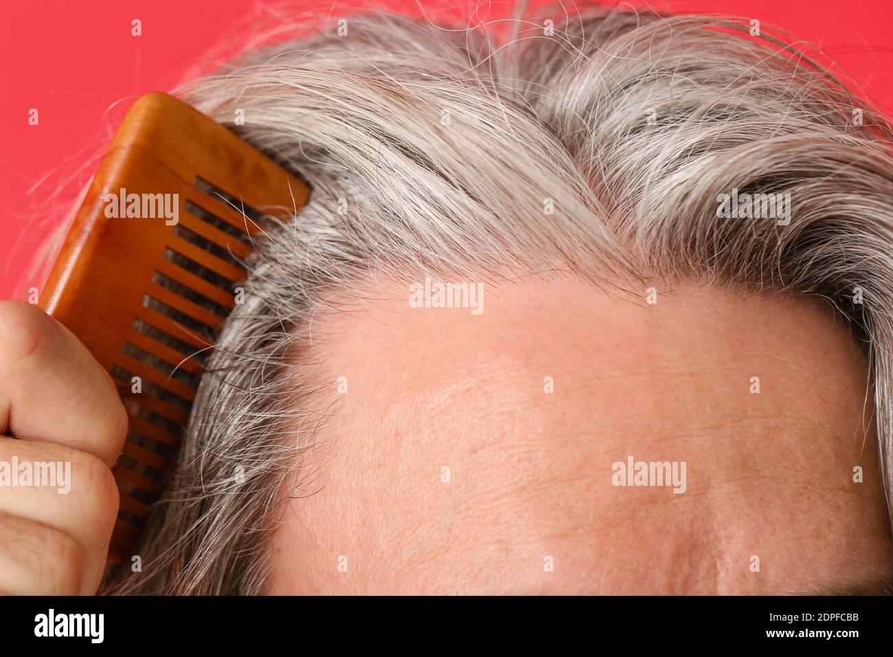 Senior man combing hair on color background, closeup Stock Photo - Alamy