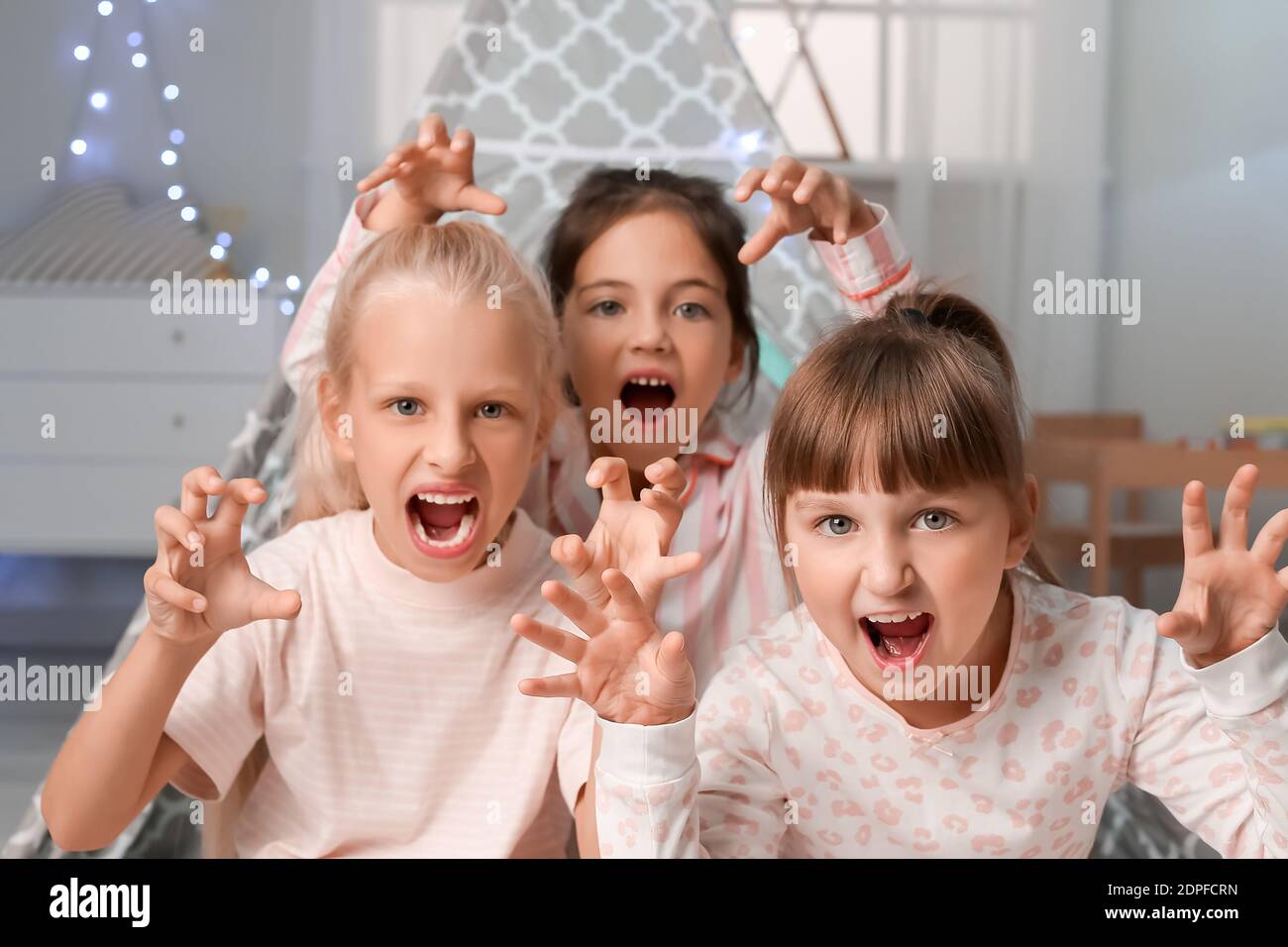 Grimacing little girls in bedroom Stock Photo - Alamy