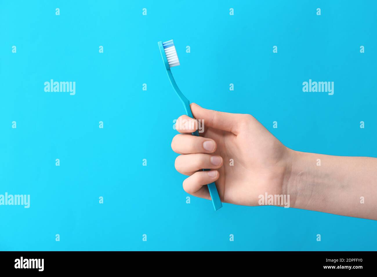 Hand with toothbrush on color background Stock Photo - Alamy