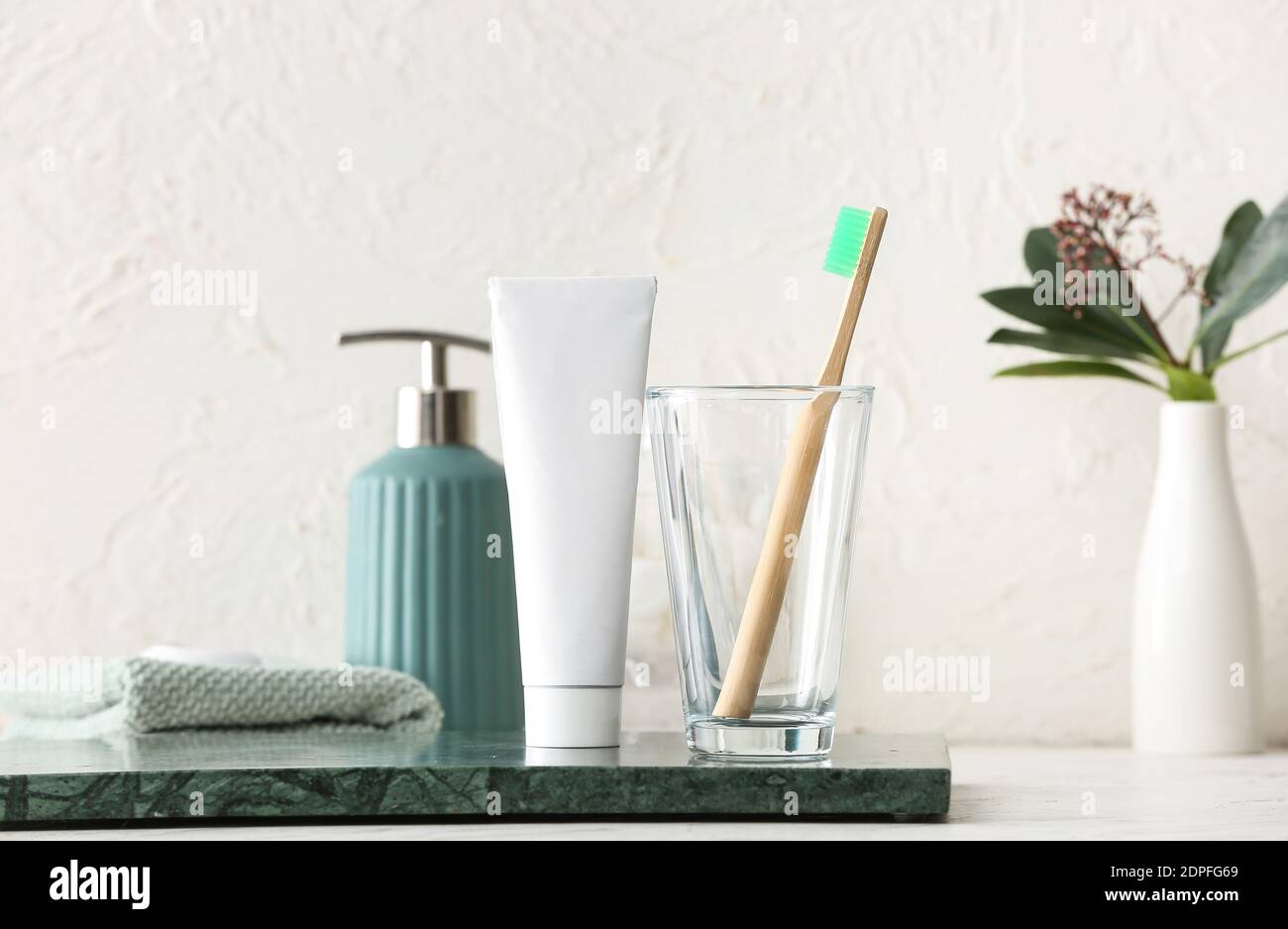 Holder with wooden toothbrush and toothpaste on table in bathroom Stock ...