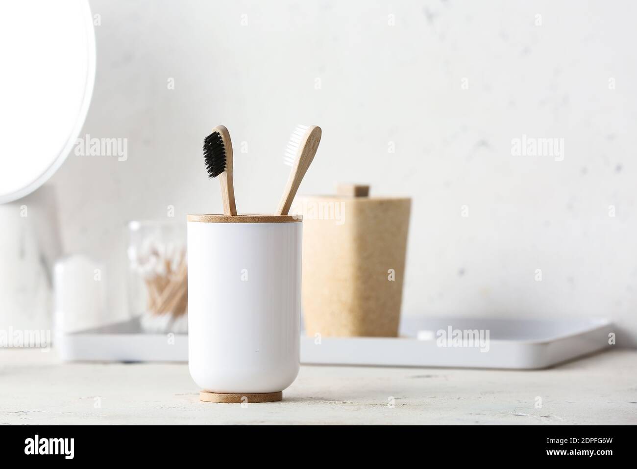 Holder with wooden toothbrushes on table in bathroom Stock Photo - Alamy