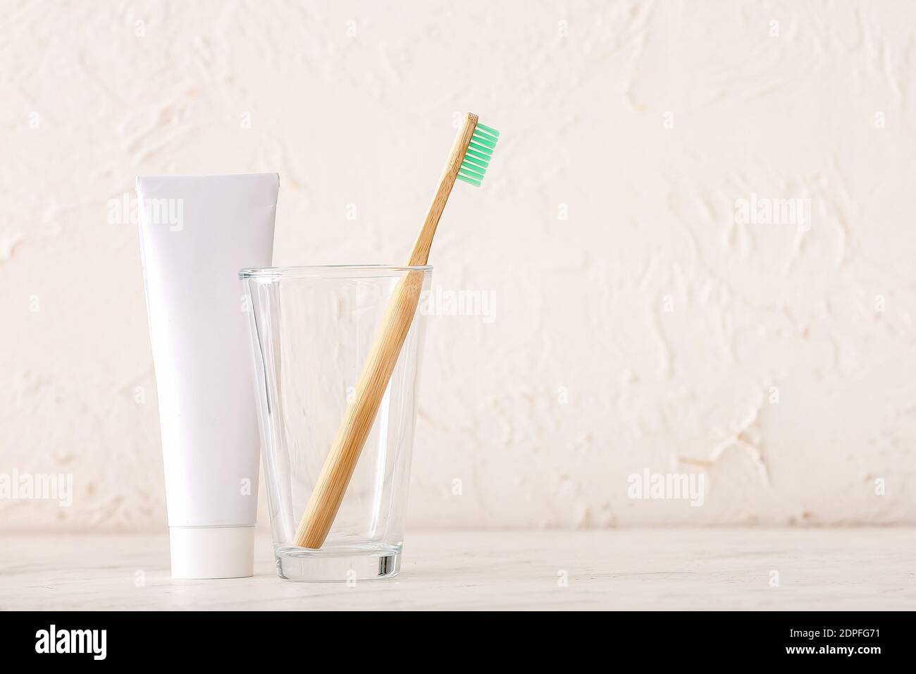 Holder with wooden toothbrush and toothpaste on table in bathroom Stock ...