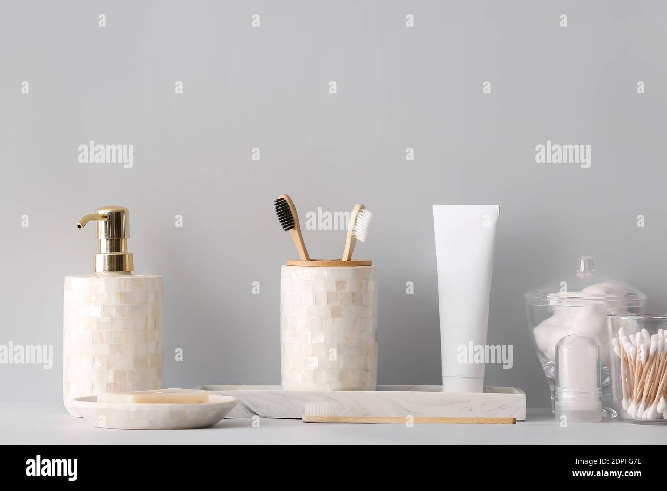 Holder with wooden toothbrushes and toothpaste on table in bathroom ...