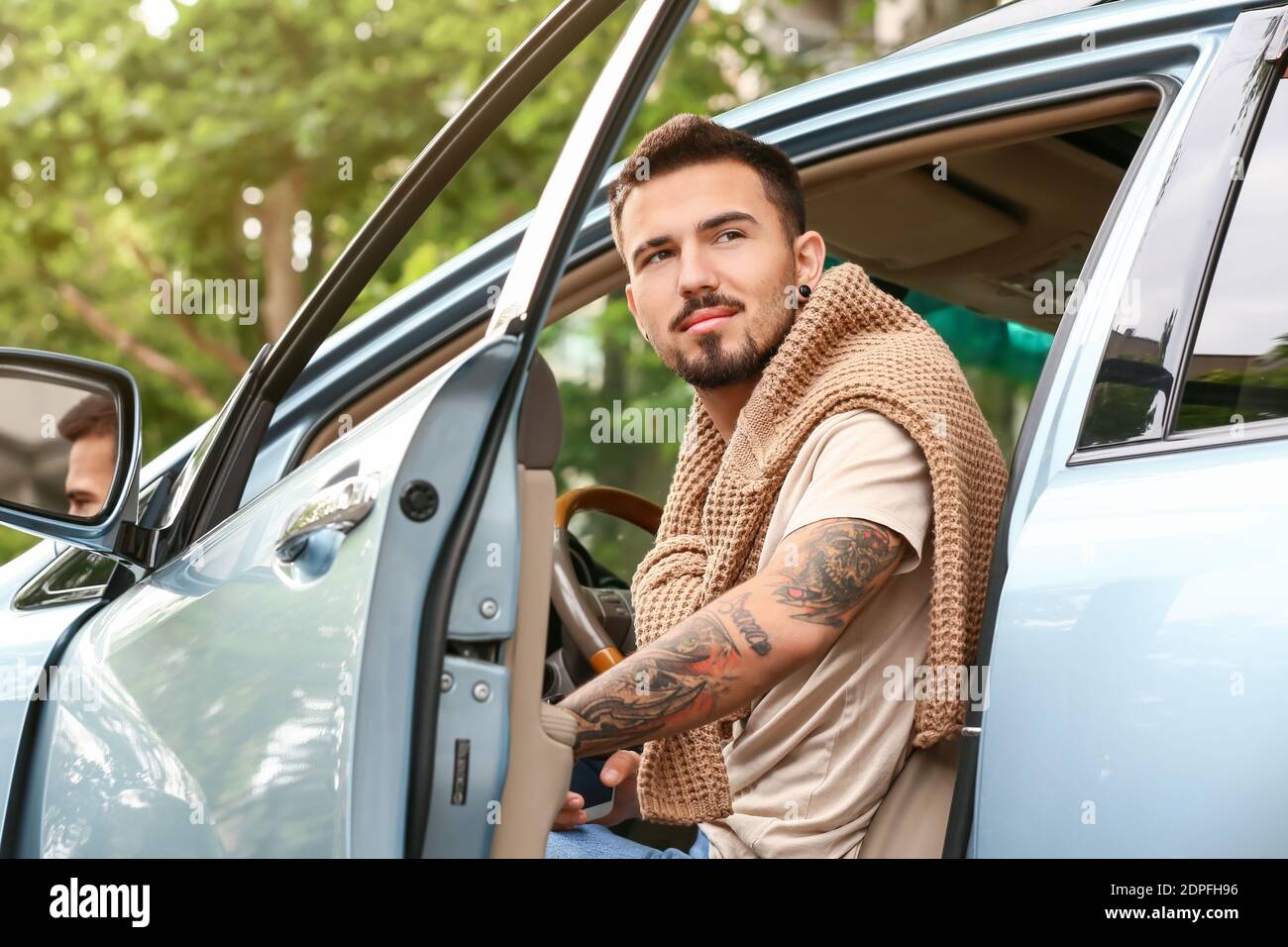 Handsome man getting out of modern car Stock Photo - Alamy