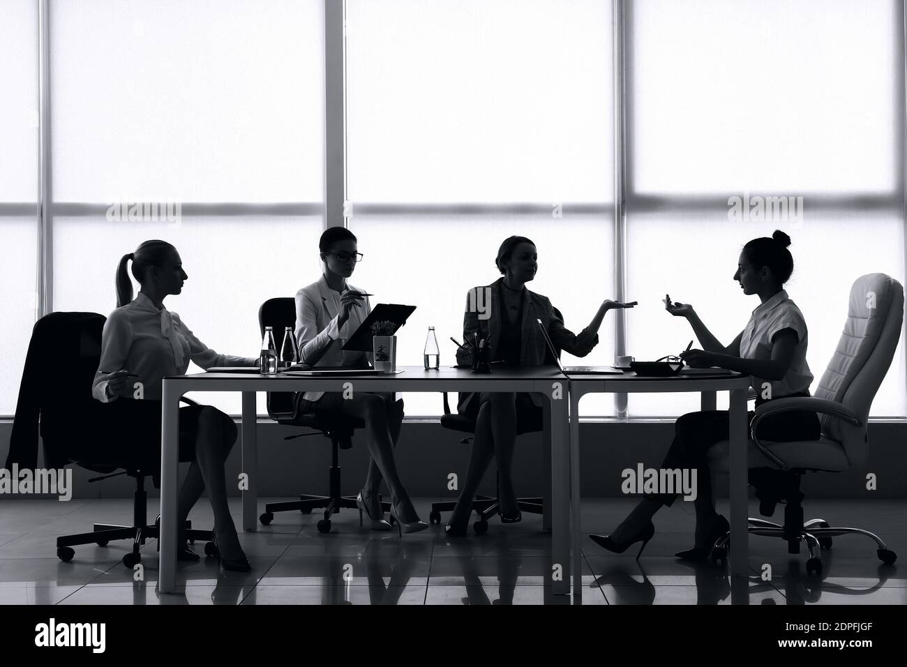 Silhouettes of businesswomen working in office Stock Photo - Alamy