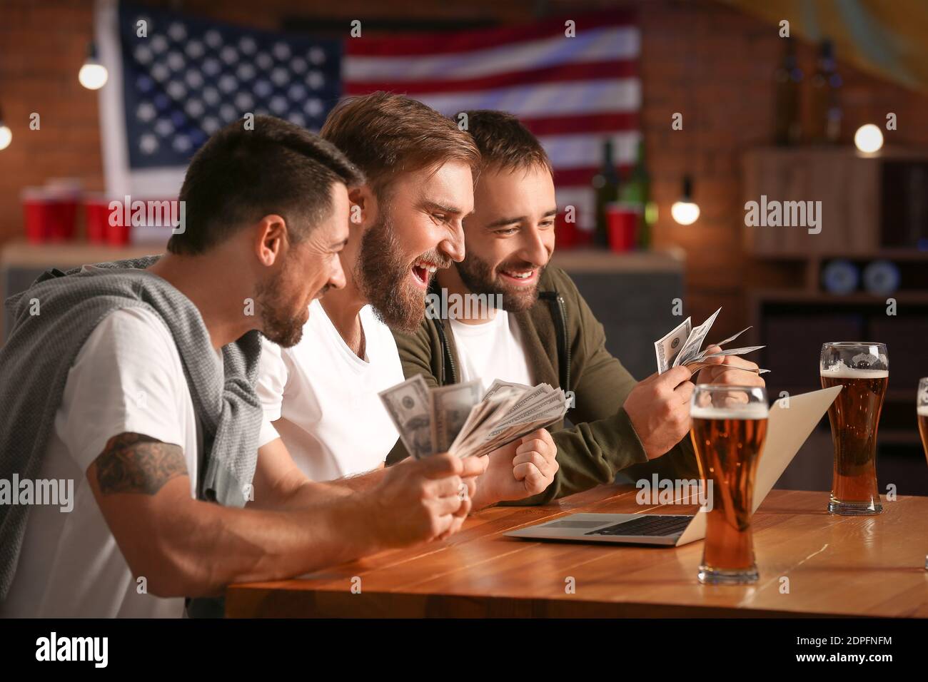 Happy men after winning of their sports bets in pub Stock Photo - Alamy
