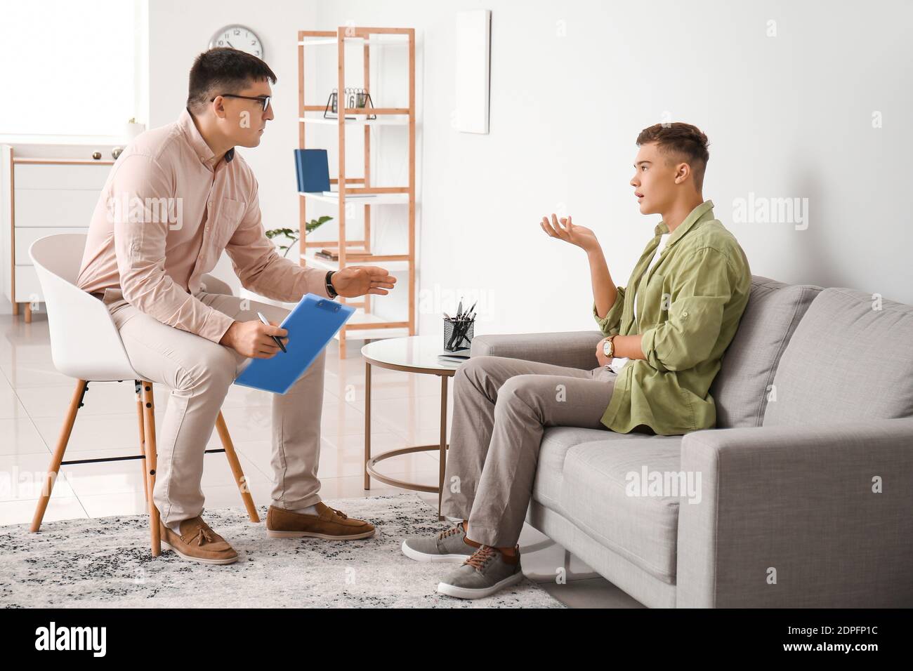 Psychologist working with teenage boy in office Stock Photo - Alamy
