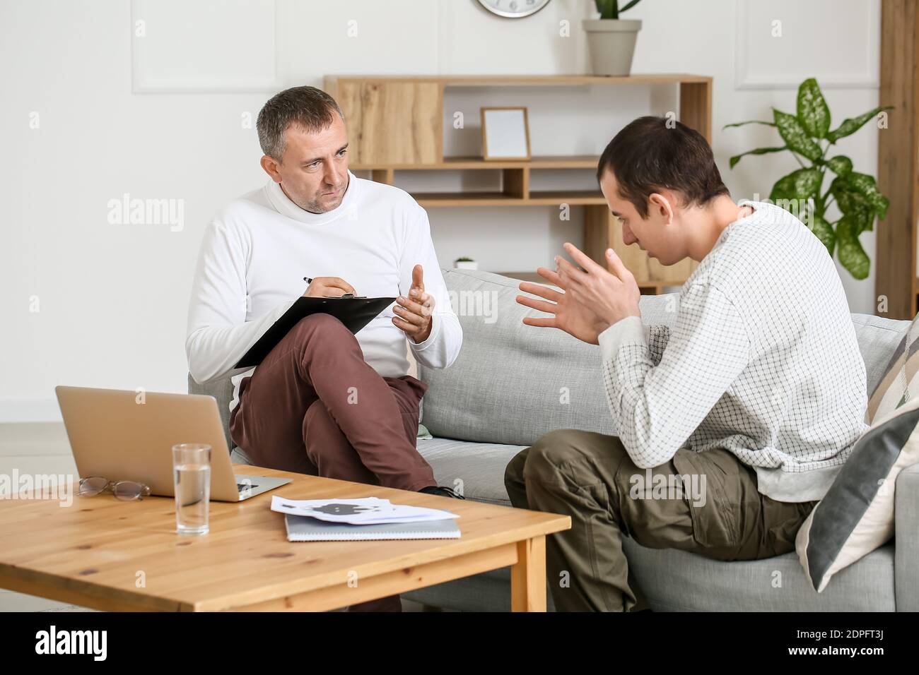 Male psychologist working with patient in office Stock Photo - Alamy