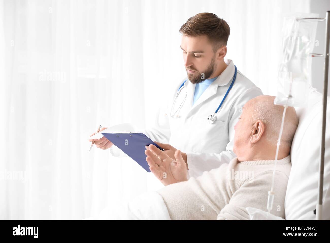 Doctor and senior man undergoing course of chemotherapy in clinic ...