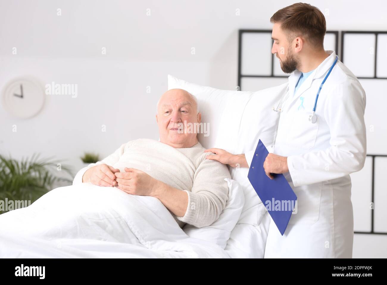 Doctor and senior man undergoing course of chemotherapy in clinic ...