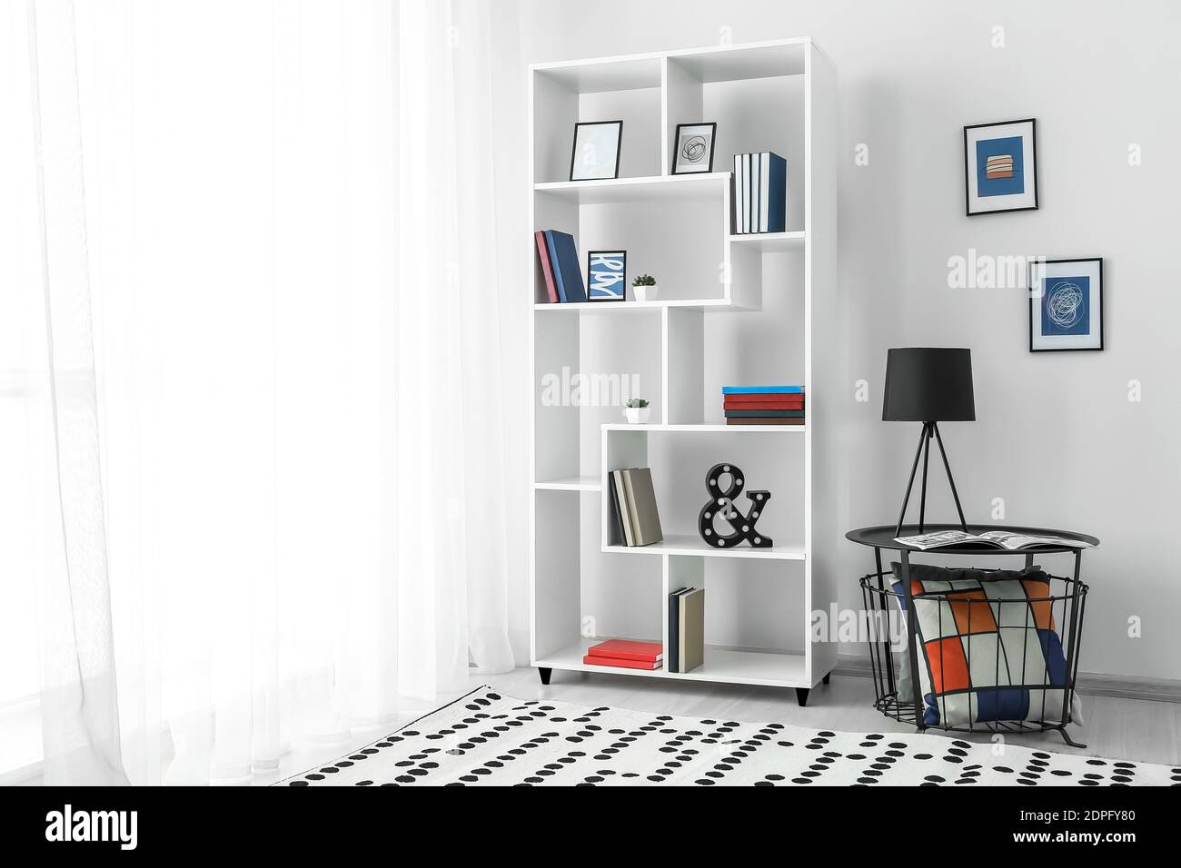 Interior of modern room with shelf unit and table Stock Photo - Alamy