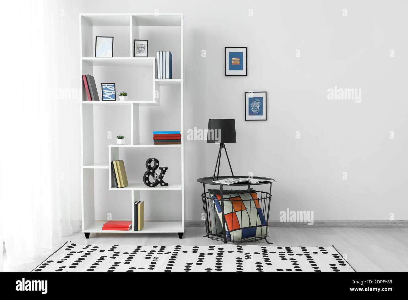 Interior of modern room with shelf unit and table Stock Photo - Alamy