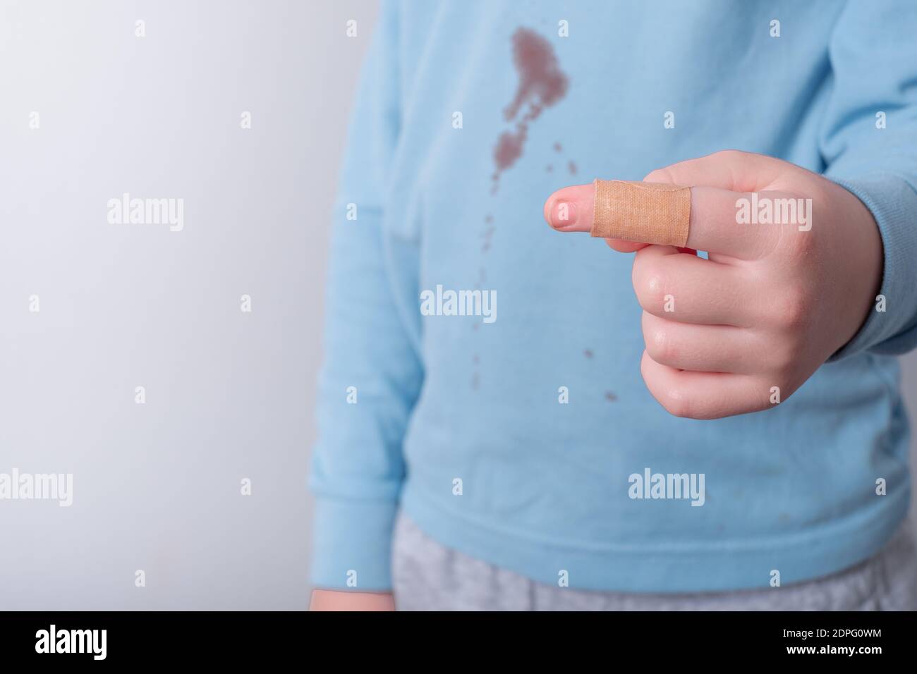 Closeup of kid finger with sticking-plaster. dirty blood stain on t ...