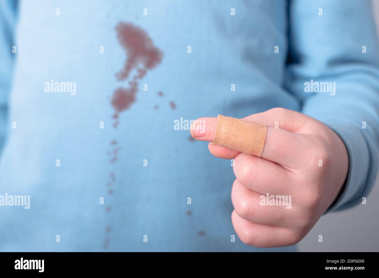 Closeup of kid finger with sticking-plaster. dirty blood stain on t ...