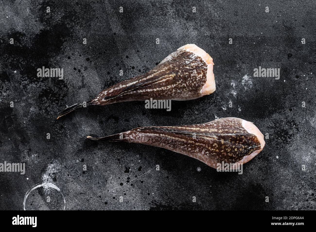 Raw monkfish without a head. Black background. Top view Stock Photo - Alamy