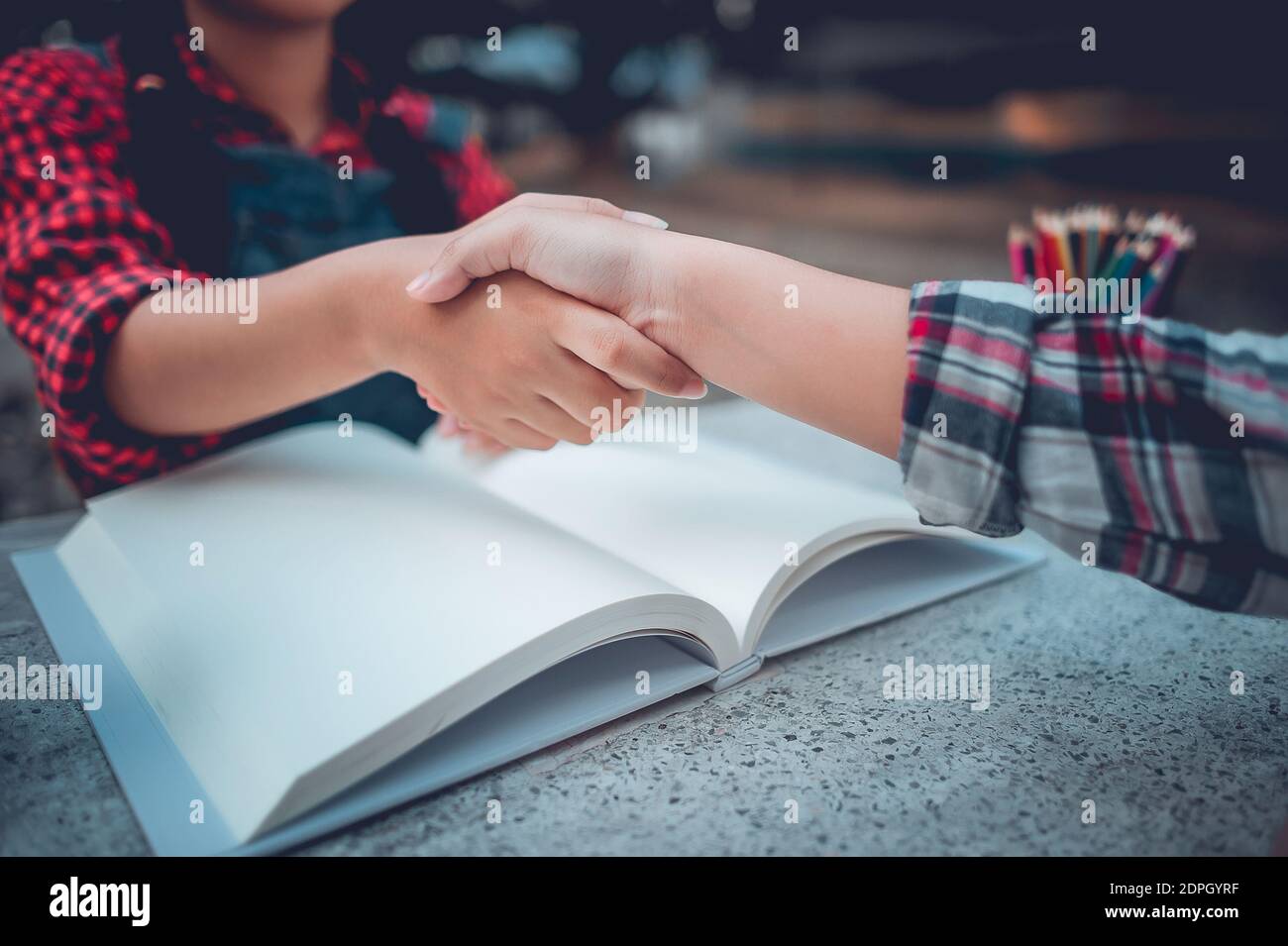 Women shaking hands book hi-res stock photography and images - Alamy
