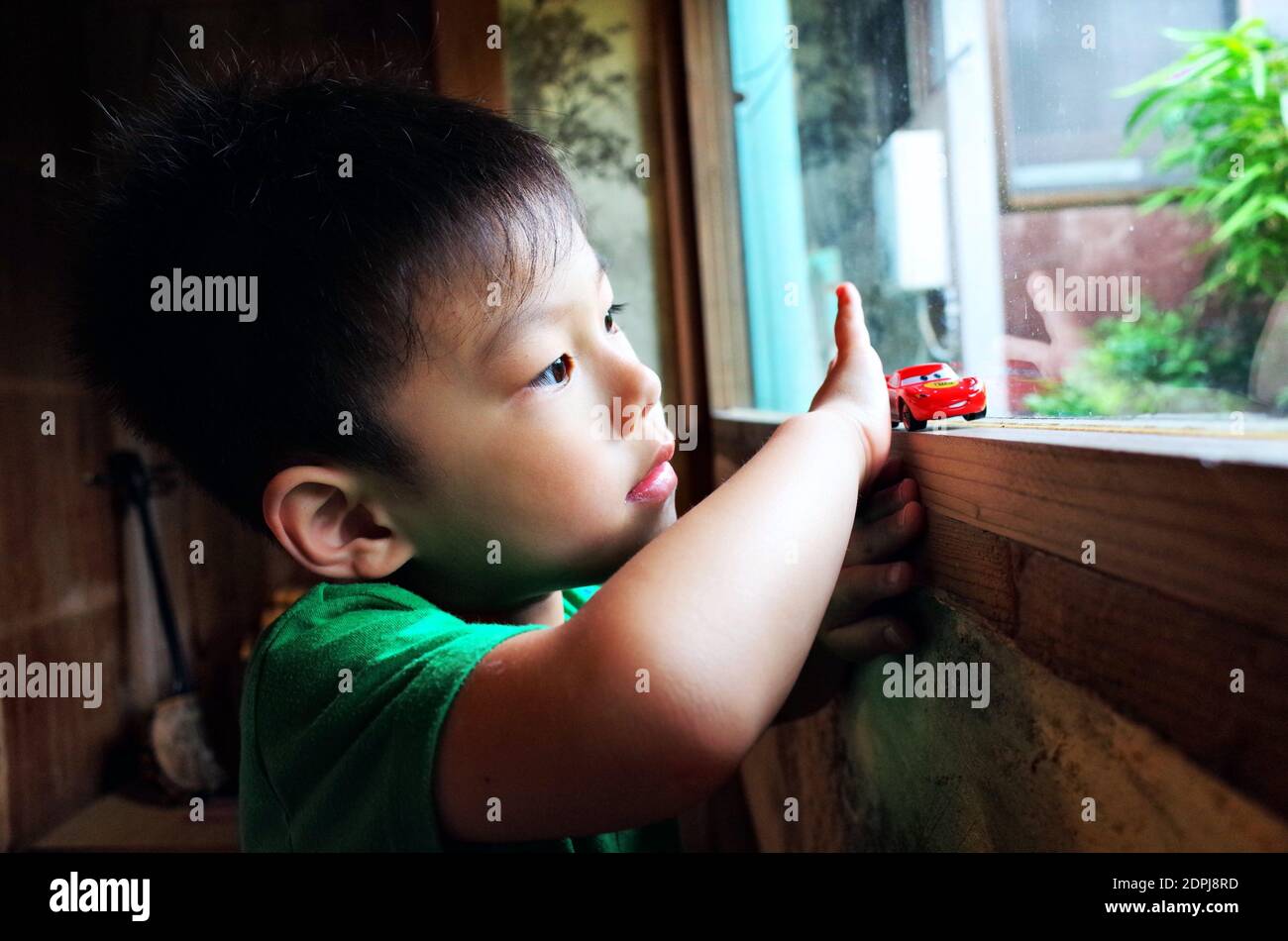 Cute Boy Playing With Toy Car On Window Sill At Home Stock Photo - Alamy