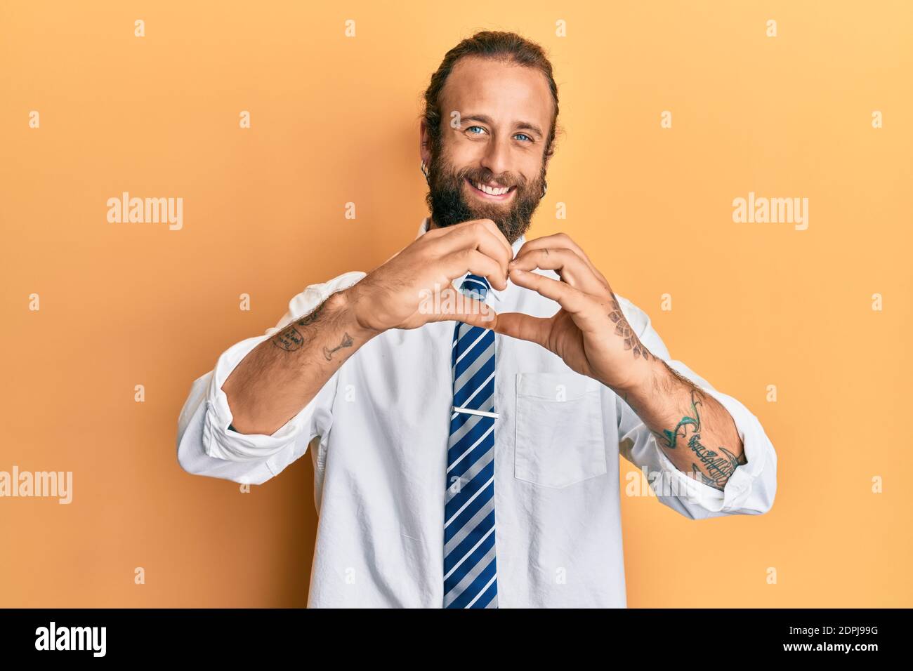 Handsome man with beard and long hair wearing business clothes smiling ...