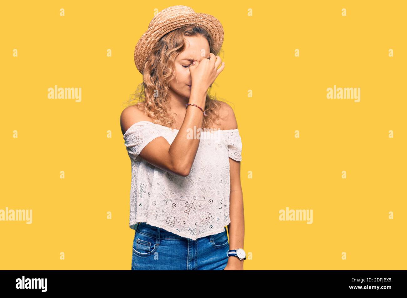 Beautiful caucasian woman wearing summer hat tired rubbing nose and ...