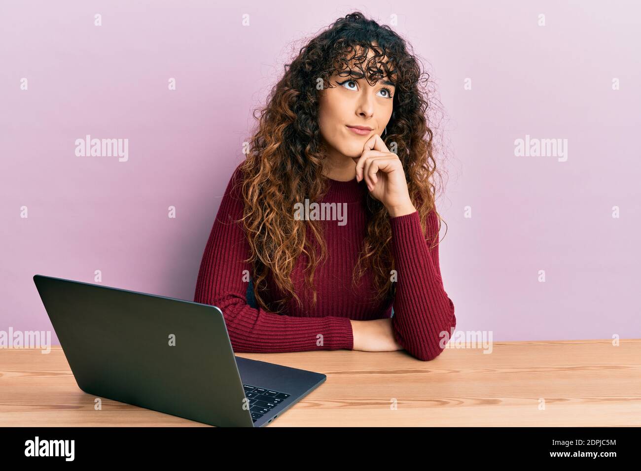 Young hispanic girl working using computer laptop thinking concentrated ...