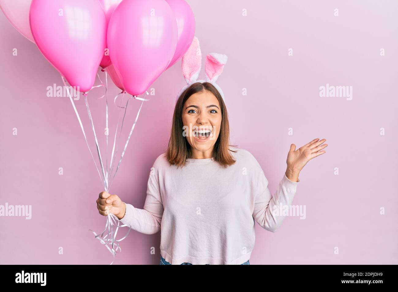 Young beautiful woman wearing cute easter bunny ears and holding ...