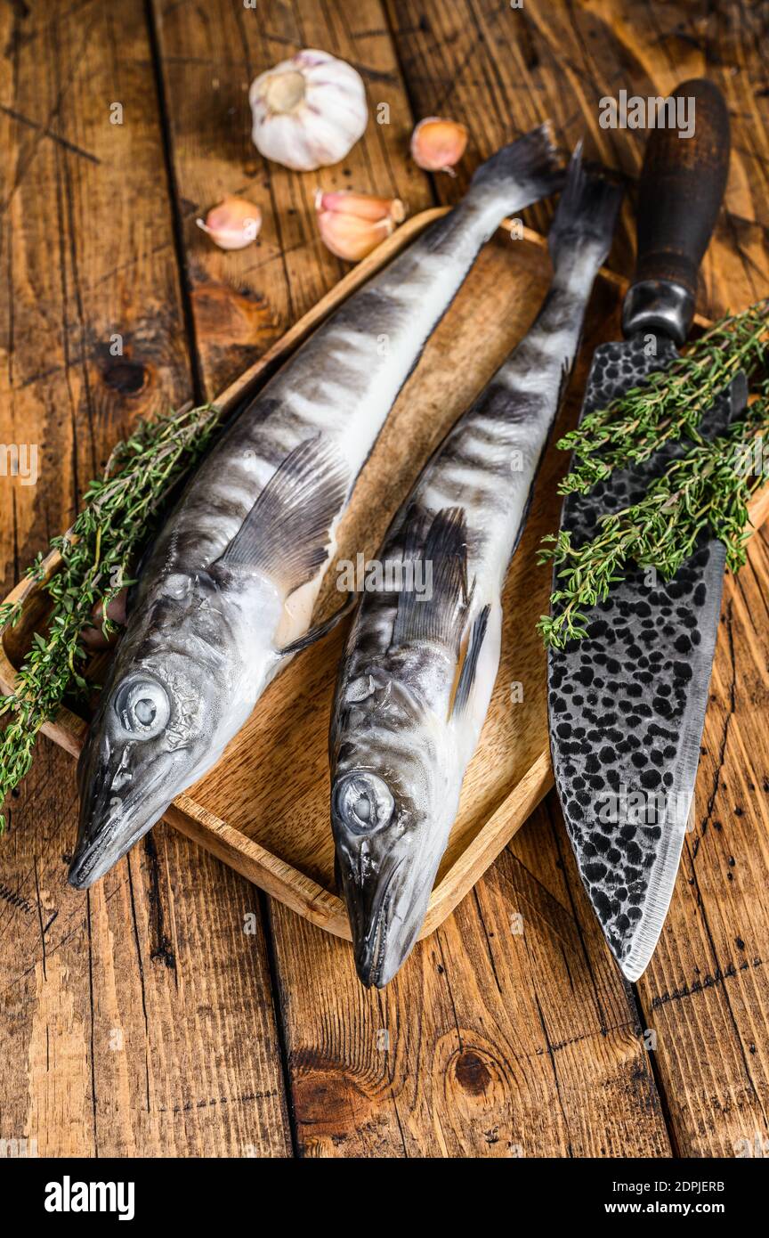 Raw mackerel icefish in a wooden tray. Wooden background. Top view ...