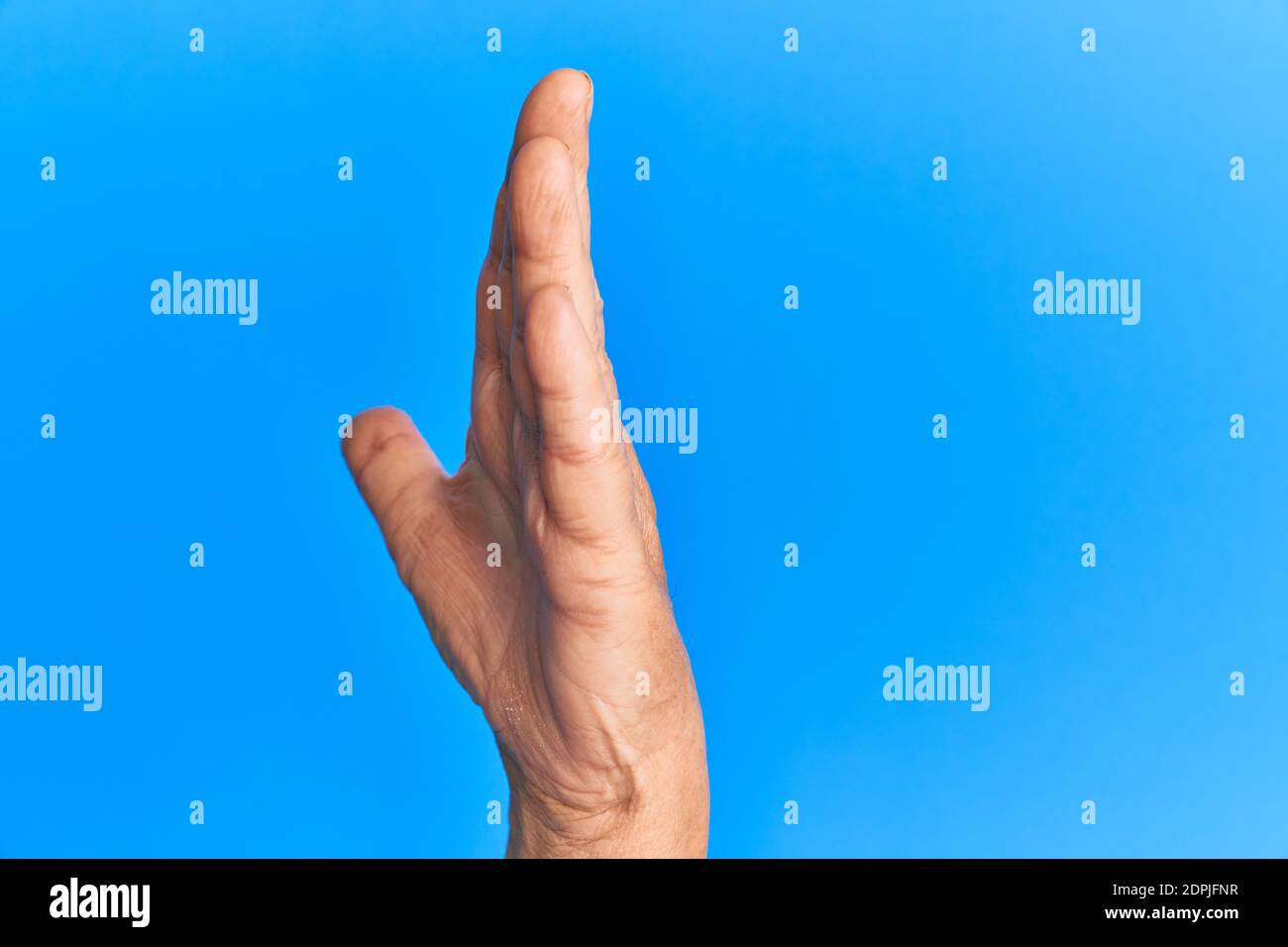 Hand of senior hispanic man over blue isolated background showing side ...