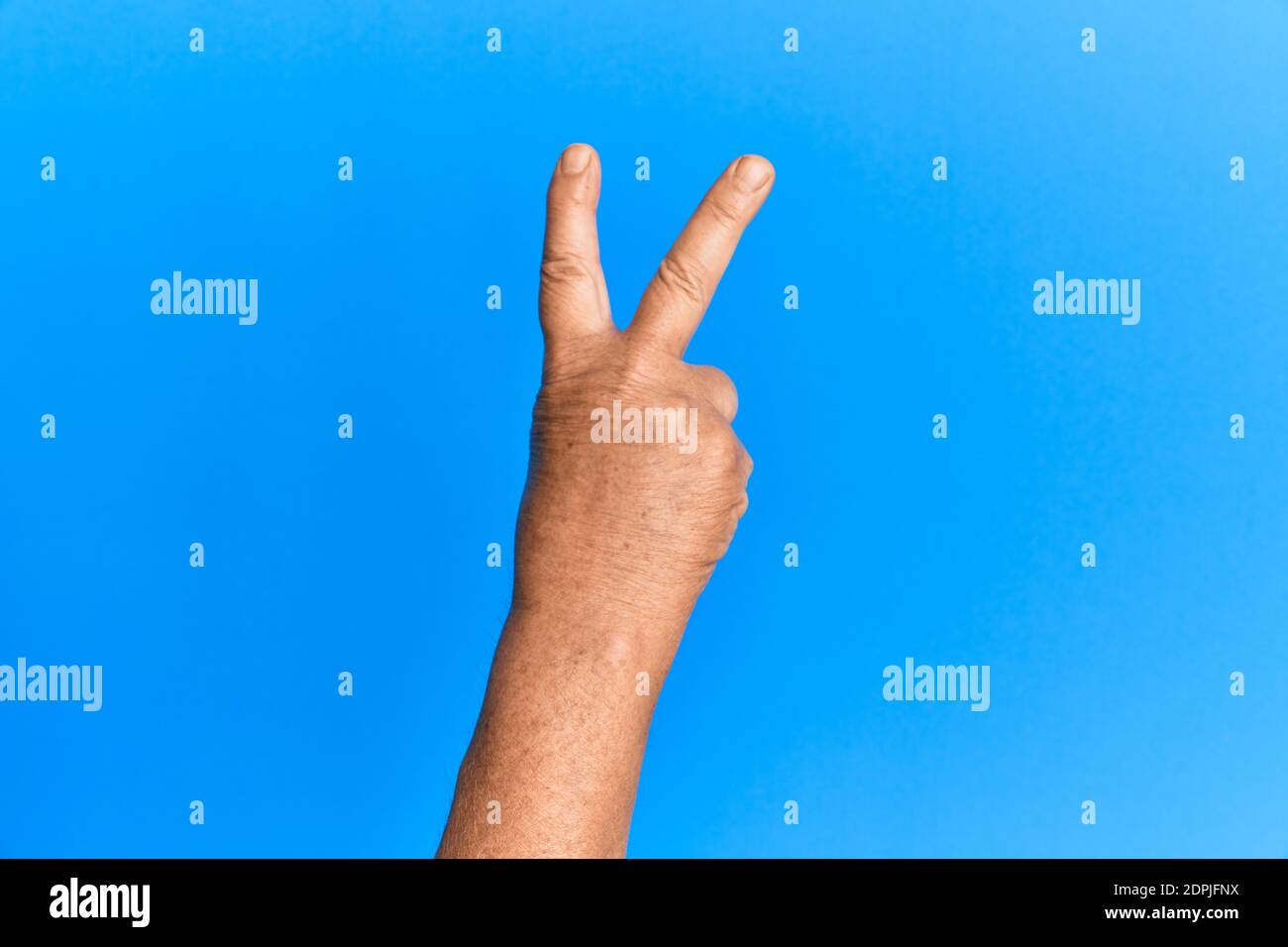 Hand of senior hispanic man over blue isolated background counting ...