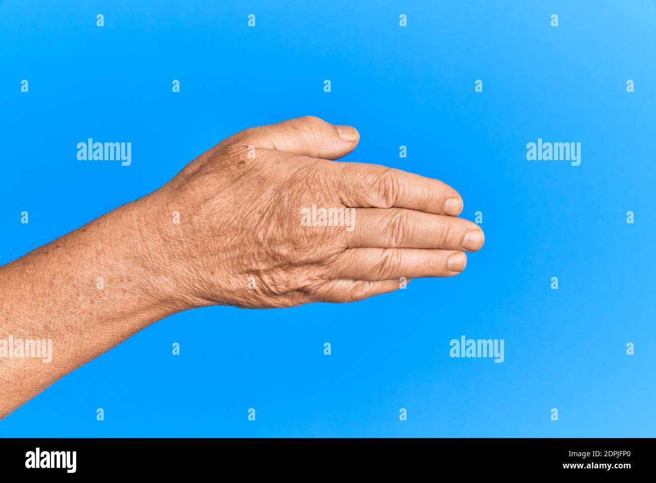 Hand of senior hispanic man over blue isolated background stretching ...