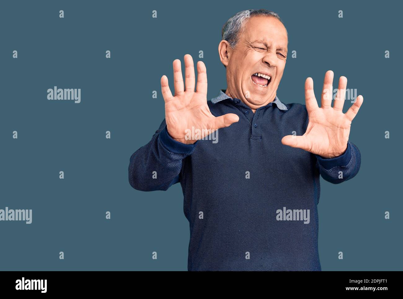 Senior handsome man wearing casual polo afraid and terrified with fear ...