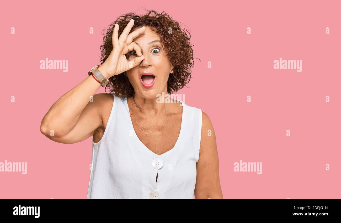 Beautiful middle age mature woman wearing casual white shirt doing ok ...