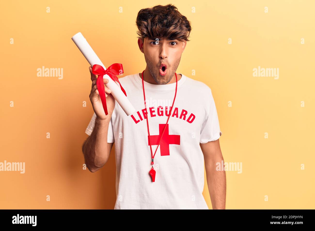 Young hispanic man wearing lifeguard t shirt using binoculars scared ...